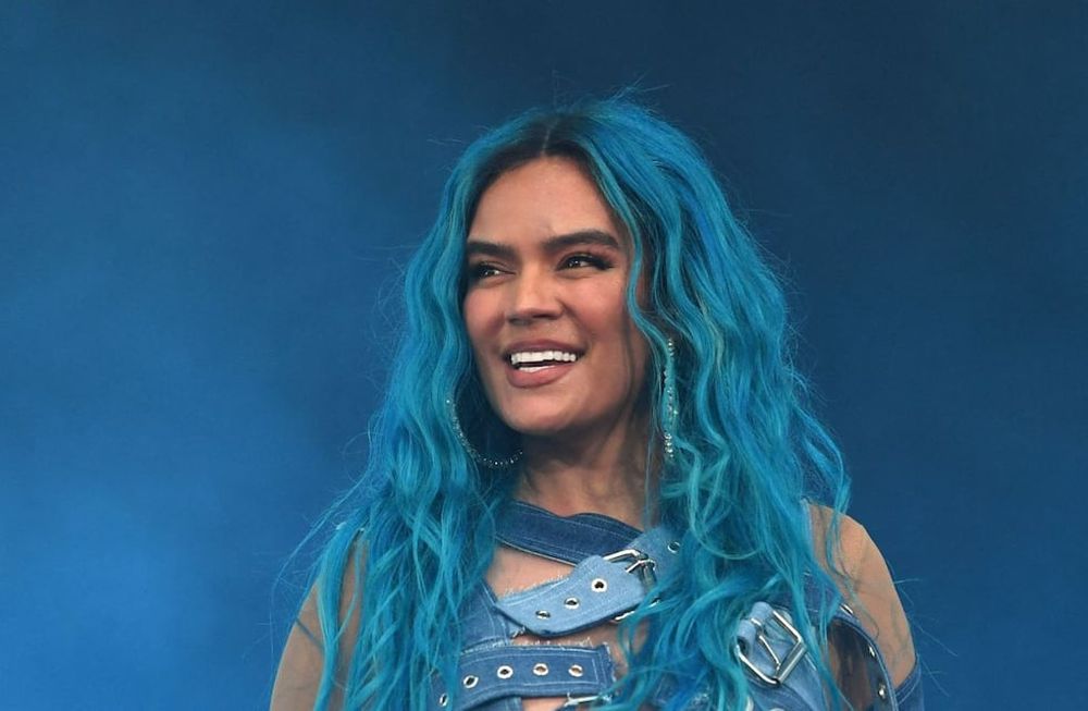 De costado, Karol G hizo alarde de sus curvas y posó con una microbikini turquesa de tiritas